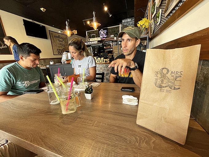 Colorful drinks in mason jars signal the start of a proper meal. The brown paper bag stands ready for leftovers—though there rarely are any.