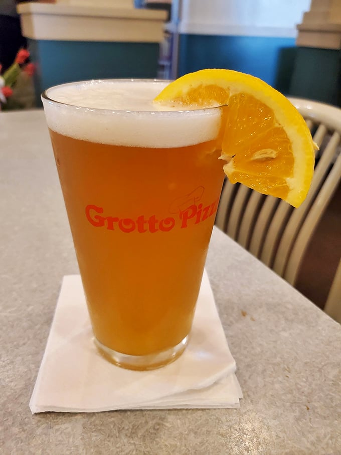 A cold beer with a citrus garnish—because sometimes the perfect pairing for great food is a moment of liquid relaxation in a Grotto-branded glass.