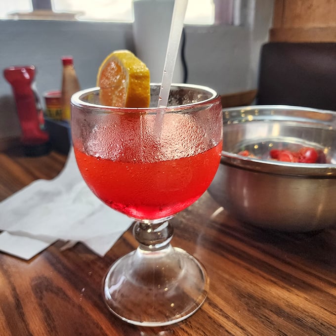 Ruby-red cocktail catching the light – because sometimes fishing stories need a little liquid encouragement.