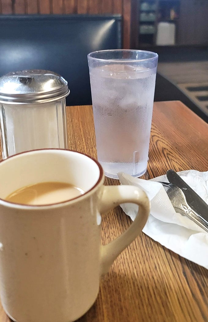 Simple pleasures: hot coffee in a sturdy mug, ice water in a tall glass—the opening act before the main event arrives.
