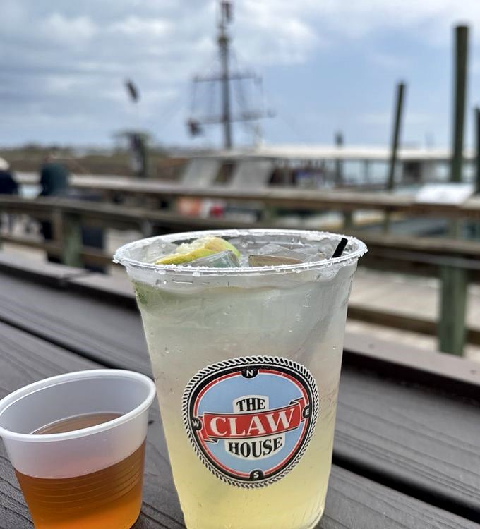 A margarita with The Claw House logo—because nothing says "vacation mode activated" like a cold drink with a water view.