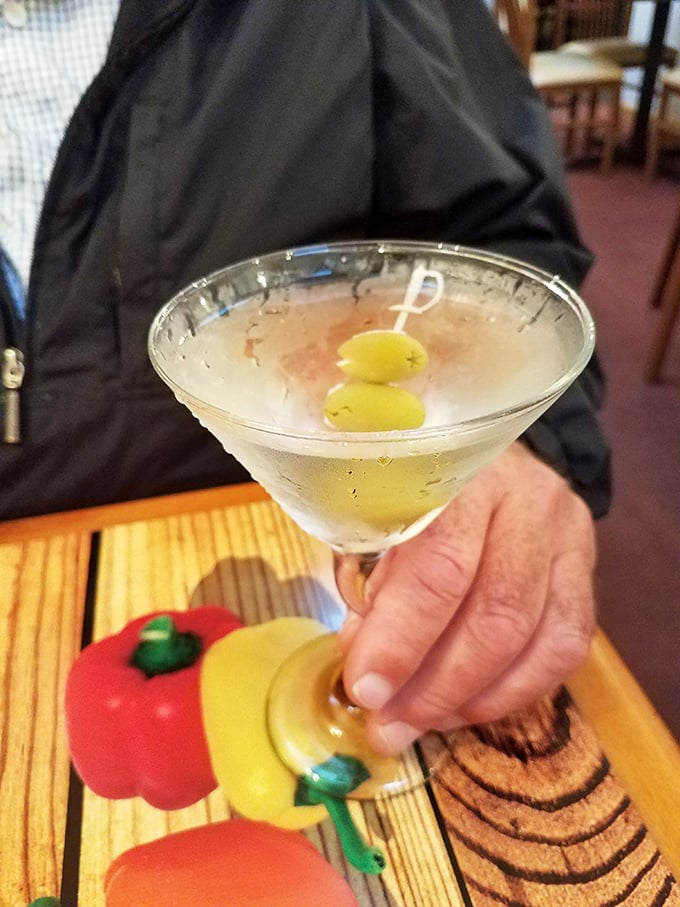 A classic martini with olives—because sometimes pizza deserves a sophisticated dance partner instead of just beer, like pairing sneakers with a tuxedo.