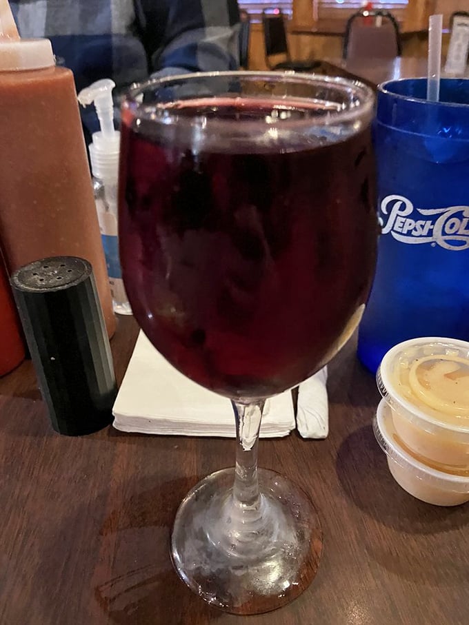 A glass of house wine stands ready to complement your seafood feast—because sometimes the simple pleasures are the best.