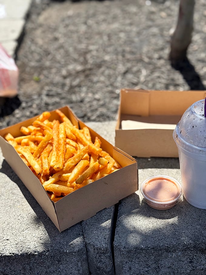These aren't just fries—they're golden happiness sticks, perfectly positioned next to that essential cup of Utah's famous fry sauce.