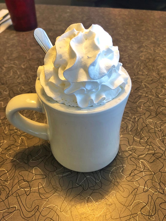Hot chocolate that wears its whipped cream crown like royalty. Not a beverage—a warm hug in ceramic form.