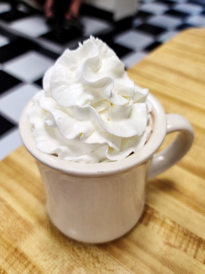 This isn't just hot chocolate—it's a warm hug in a mug, topped with a cloud of whipped cream that defies both gravity and restraint.