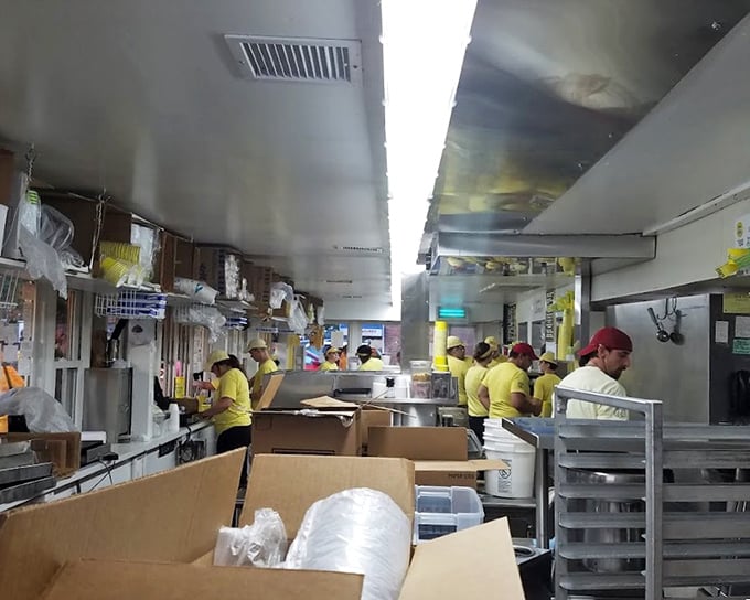 The assembly line of joy—where minimum-wage workers become maximum-happiness providers. Every yellow shirt represents years of custard-crafting expertise.
