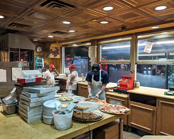 Behind the counter, pizza artisans perform their daily ritual. Like watching Olympic athletes, except the gold medals are edible.