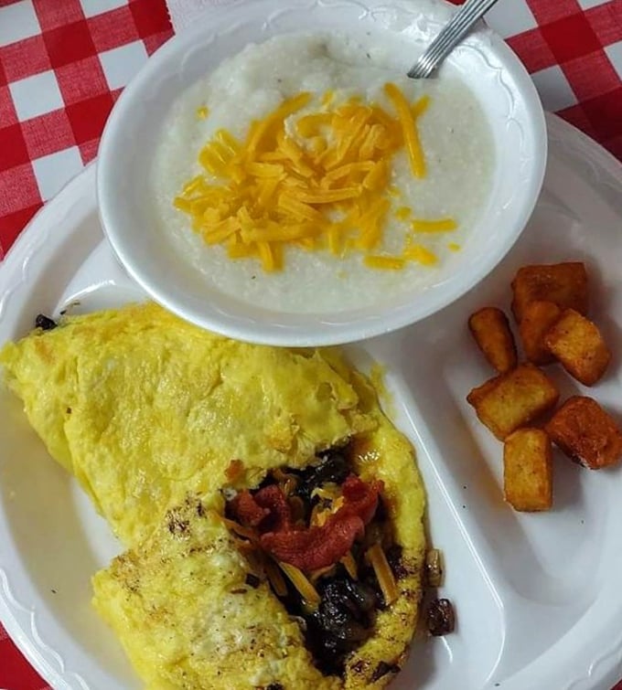 Breakfast perfection on a plate—a fluffy omelet alongside creamy cheese grits proves Southern mornings start with serious sustenance.