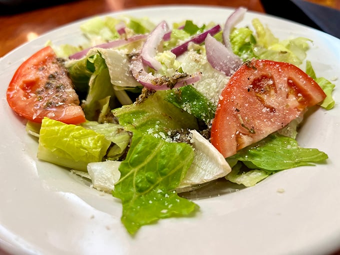 A simple house salad that actually deserves attention – crisp lettuce, ripe tomatoes, and red onions with just the right dressing.
