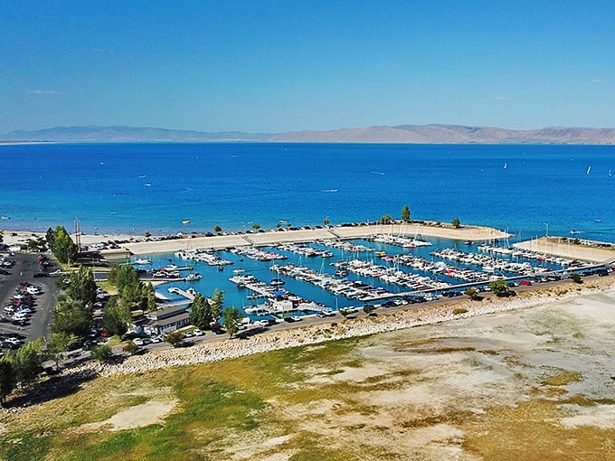 From above, the marina looks like a carefully arranged model set—tiny boats in perfect formation on impossibly blue water.