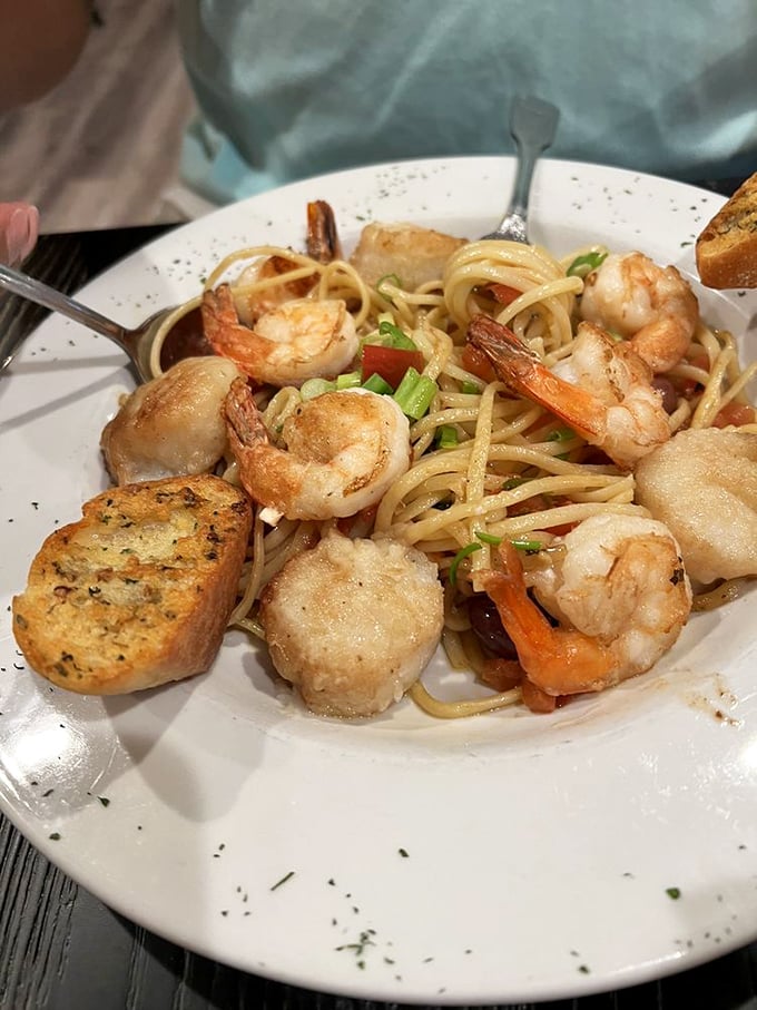 Plump shrimp nestled among pasta strands with garlic bread standing guard. A seafood pasta that would make even an Italian grandmother nod in approval.