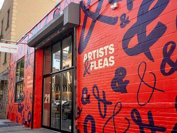 That bold red wall announces Artists & Fleas like a gallery opening, promising handmade and vintage goods worth discovering inside.