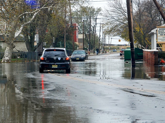 A street-turned-stream, where cars wade cautiously as if auditioning for “Shark Week: Suburban Edition.