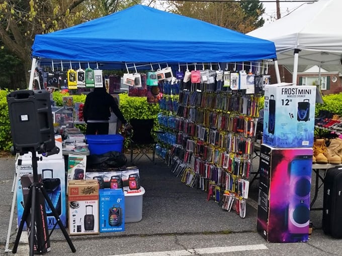 Vendors showcase electronics and accessories under blue canopies, bringing modern convenience to this traditional outdoor market setting.