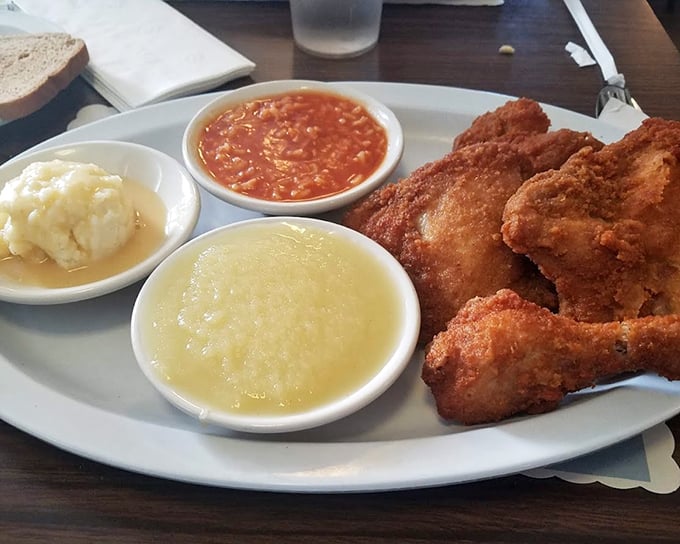 A plate that proves dark meat deserves the spotlight – juicy thighs alongside that signature hot sauce, applesauce, and mashed potatoes create the comfort food trifecta.