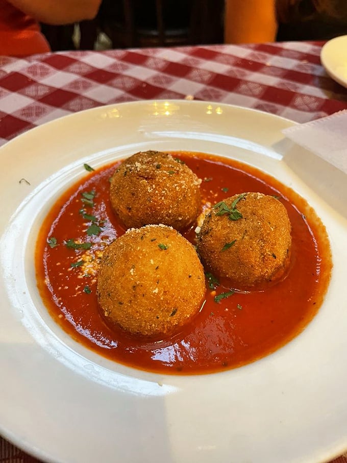 These golden arancini balls sit in their tomato sauce like sopranos waiting for their cue—crispy outside, creamy risotto within.