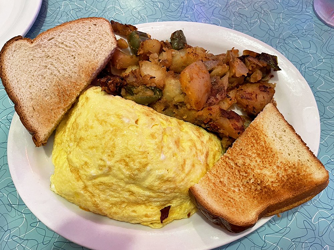 The holy trinity of breakfast perfection: a fluffy omelet, crispy home fries, and toast standing by for yolk-sopping duty.