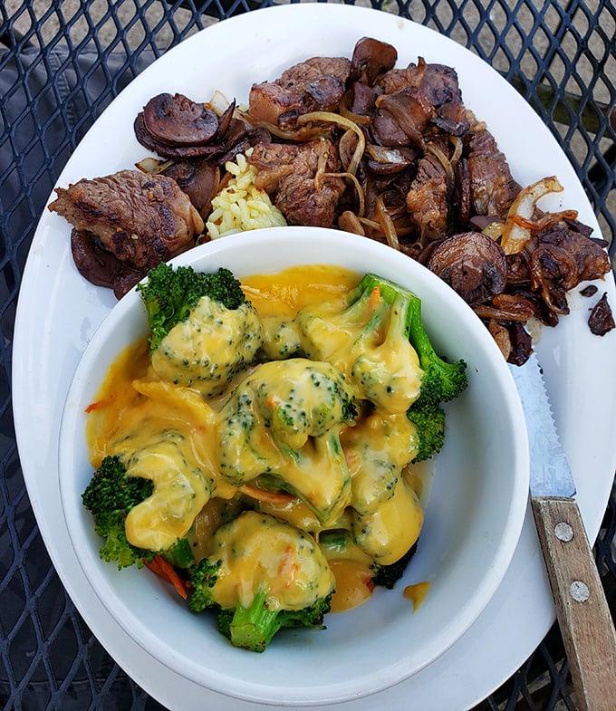 Tender beef tips meet cheesy broccoli in a harmony that proves barbecue joints can master more than just smoke.