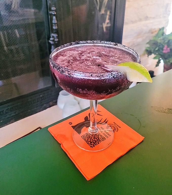 The blueberry margarita's vibrant purple hue and sugar-rimmed glass promise a sweet-tart flavor adventure that delivers with every sip.