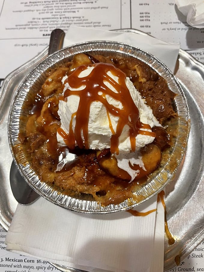 Apple bread pudding topped with whipped cream and caramel – because after a barbecue feast, your sweet tooth deserves its moment too.
