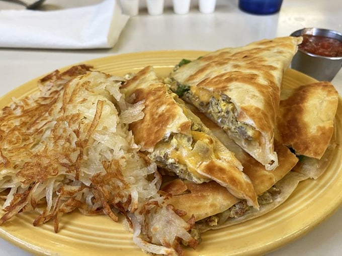 The breakfast quesadilla arrives golden and stuffed with morning goodness, while hash browns stand guard like crispy sentinels of satisfaction.
