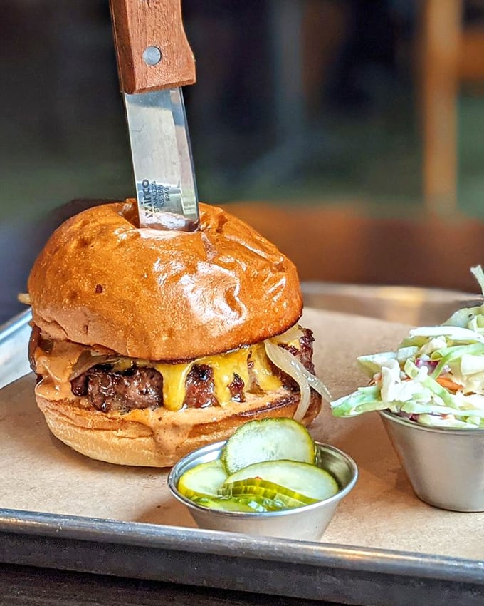 A burger that's not playing around—knife-stabbed for dramatic effect and oozing with melted cheese and smoky attitude.
