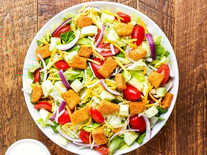 Even the side salad gets the star treatment—crisp greens, crunchy croutons, and shredded cheese create the perfect opening act for the main event.
