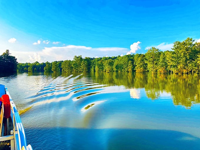 Mirror-like waters reflect a perfect blue sky—from this boat's perspective, you're floating between two heavens.