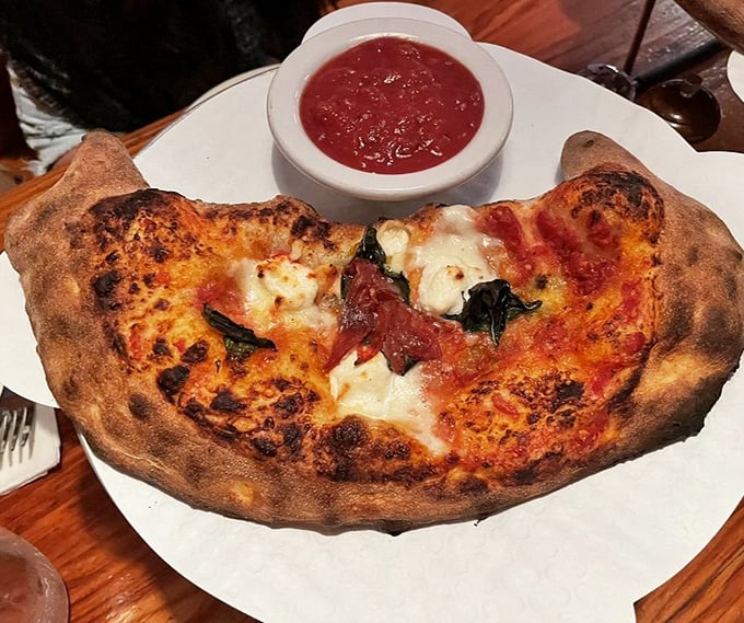 This isn't just a calzone; it's a half-moon of happiness with a side of marinara for essential dipping operations.
