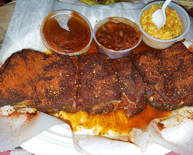 Dry-rubbed ribs in all their spice-crusted glory. That distinctive orange-red coating isn't just color – it's a flavor force field.