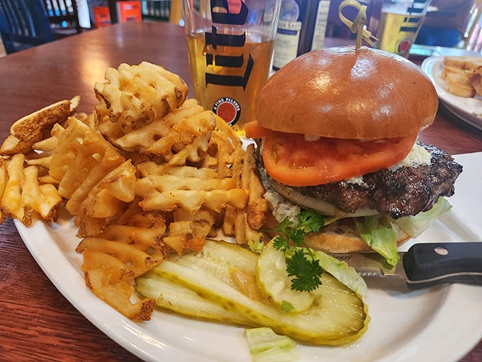 This isn't just a burger – it's a monument to American ingenuity, flanked by waffle fries and pickles standing guard like delicious sentinels.