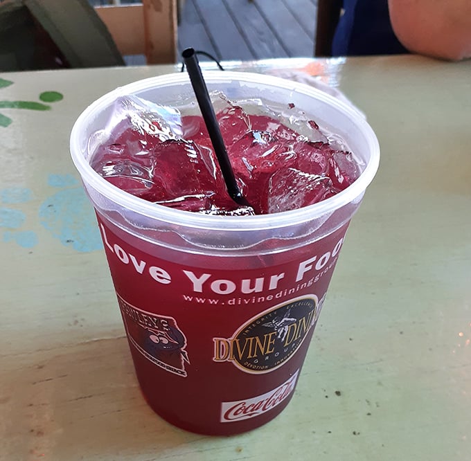 That ruby-red Southern elixir in a plastic cup – because sometimes the perfect accompaniment to seafood comes with free refills and nostalgic sweetness.