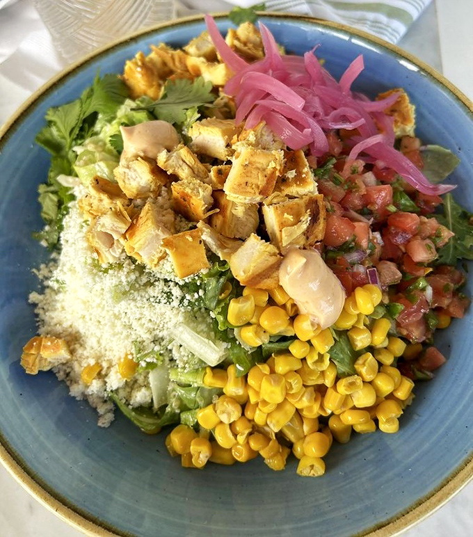 A colorful bowl that eats like a Miami sunset—bright corn, pink pickled onions, and protein playing together in perfect harmony.