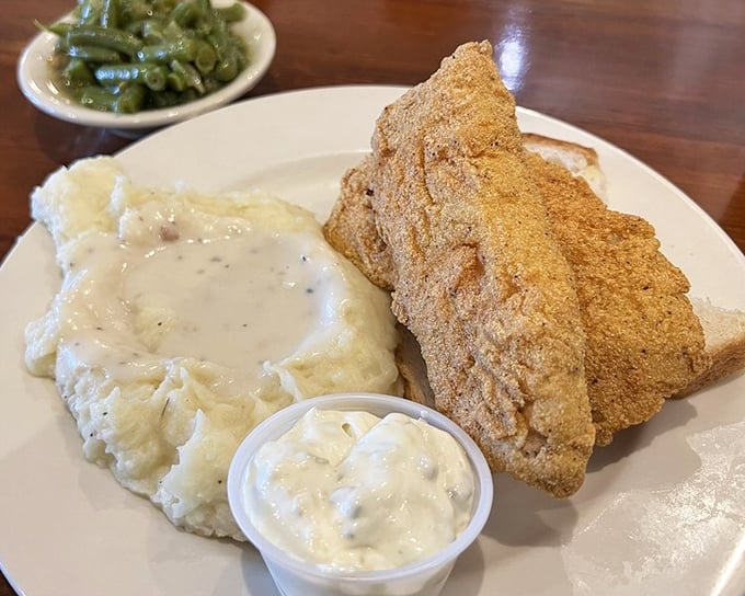 The fish arrives golden and crisp, with fries standing at attention. No pretentious foam or reduction here—just honest-to-goodness satisfaction on a white plate.