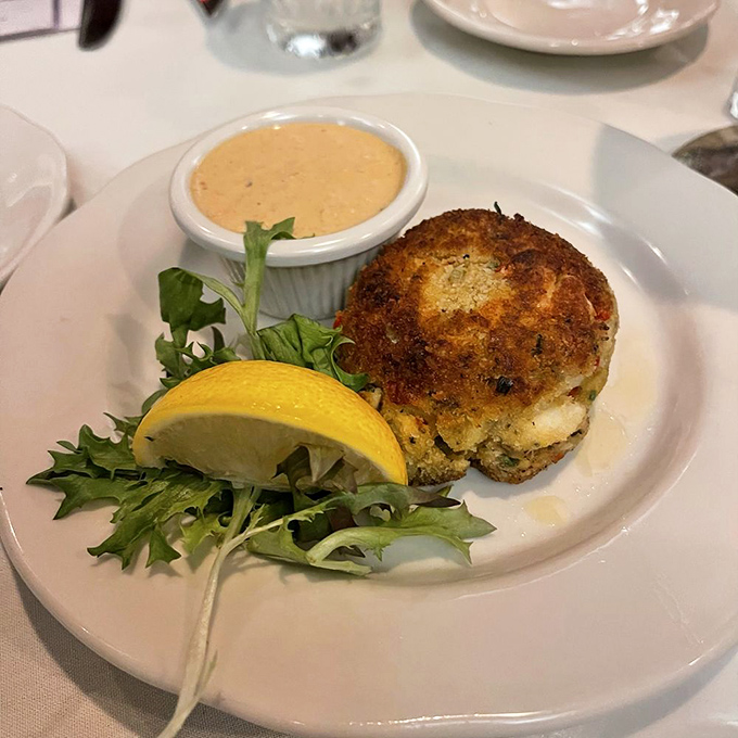A crab cake that's actually about the crab, not the cake—served with a sauce that should be bottled and sold as liquid gold.