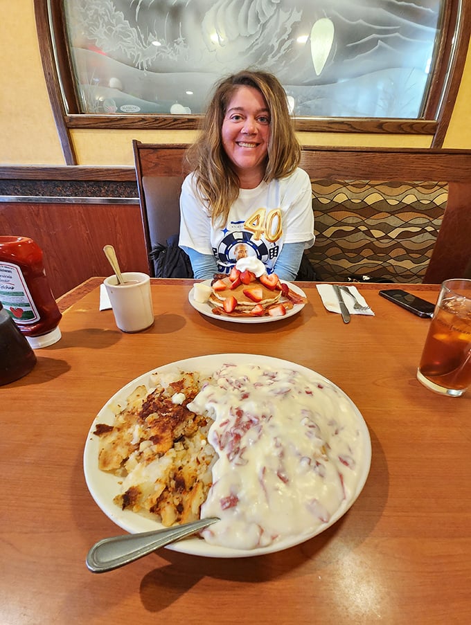 The image shows a diner patron enjoying what appears to be a celebratory meal. That smile says everything about the Shore Diner experience—pure food happiness.