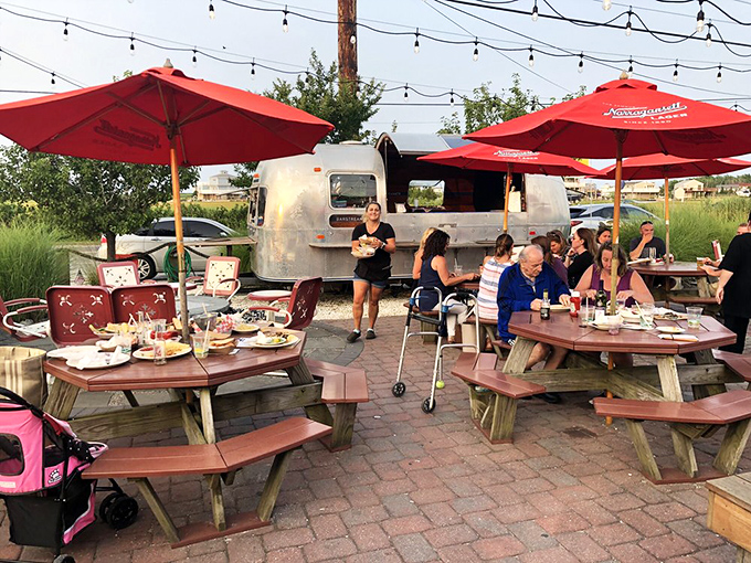 The outdoor dining area where memories are made under string lights, with that vintage Airstream adding just the right amount of retro cool to your seafood feast.