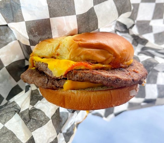 A burger that requires both hands and a strategy. The cheese doesn't just melt—it surrenders completely to its beefy companion.