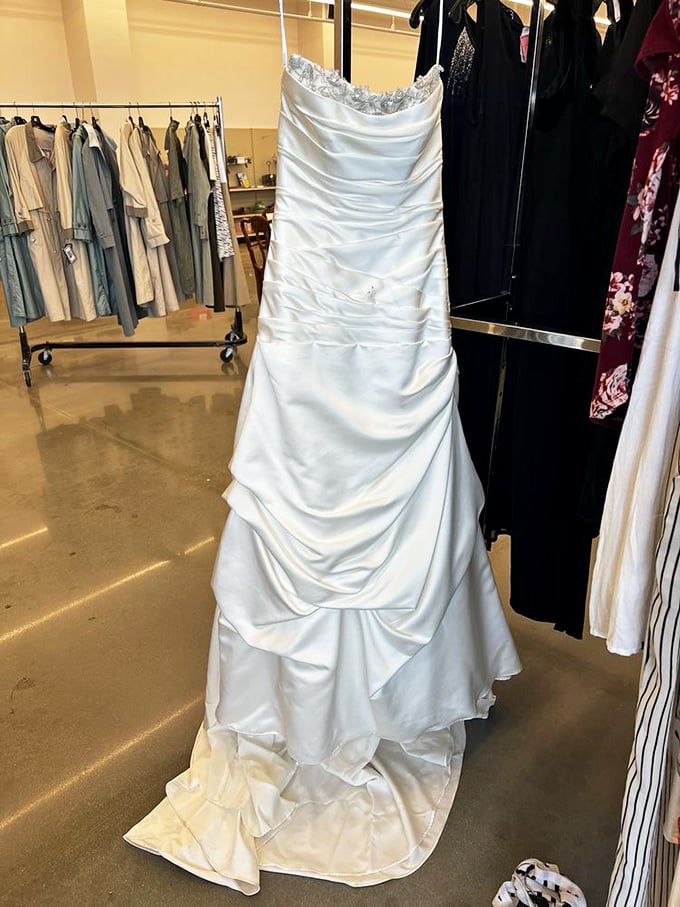 A wedding dress waits patiently for its second walk down the aisle, its satin folds holding both memories and possibilities.