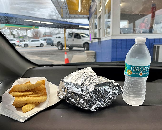 The authentic drive-in experience: steering wheel dining table, foil-wrapped burger, and fries that somehow taste better in your car.