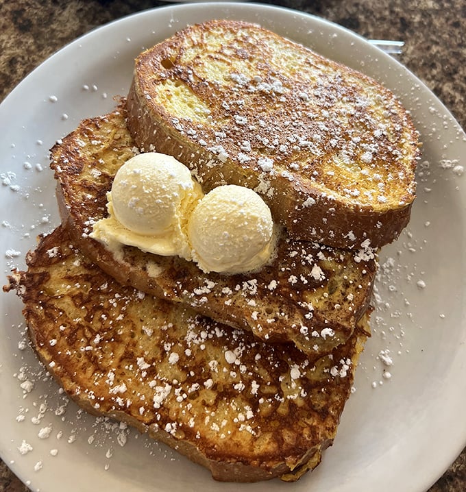 French toast that's been living its best life. Those two scoops of vanilla ice cream aren't just garnish—they're essential companions.