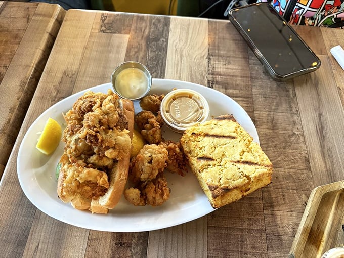 Fried seafood heaven on a plate – crispy golden morsels nestled in a soft roll with cornbread on the side. Diet plans, beware.