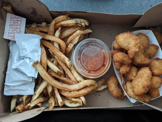 The kind of fries that remind you why potatoes deserve their place in the comfort food hall of fame, paired with golden-fried seafood perfection.