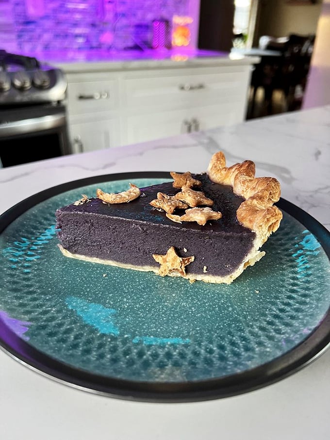 This slice of Galaxy Pie doesn't just look otherworldly—its deep purple filling and star-shaped pastry garnishes make dessert feel like an astronomical event.