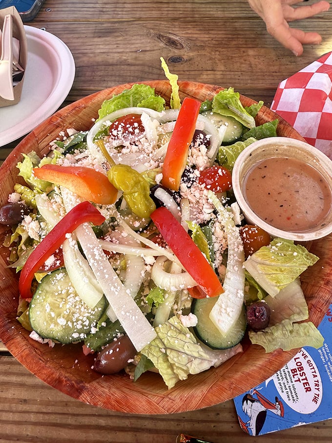 The Greek salad arrives in a wooden bowl like a Mediterranean rainbow—crisp, colorful, and crowned with just the right amount of feta.
