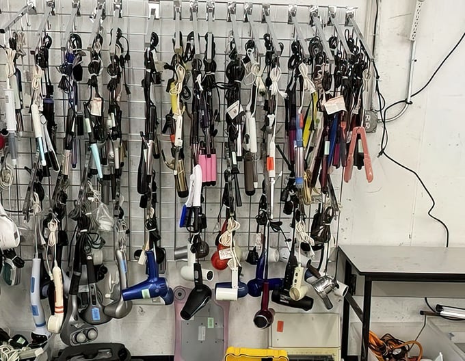 The wall of hair tools—where yesterday's styling gadgets hang like modern art, waiting for their retro revival moment.
