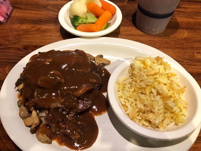 The hamburger steak arrives smothered in rich mushroom gravy, paired with perfectly seasoned rice—proof that comfort food transcends all culinary boundaries.