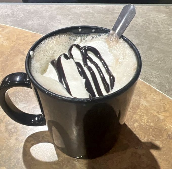Hot chocolate topped with whipped cream and chocolate drizzle – because sometimes adults need permission to drink dessert too.