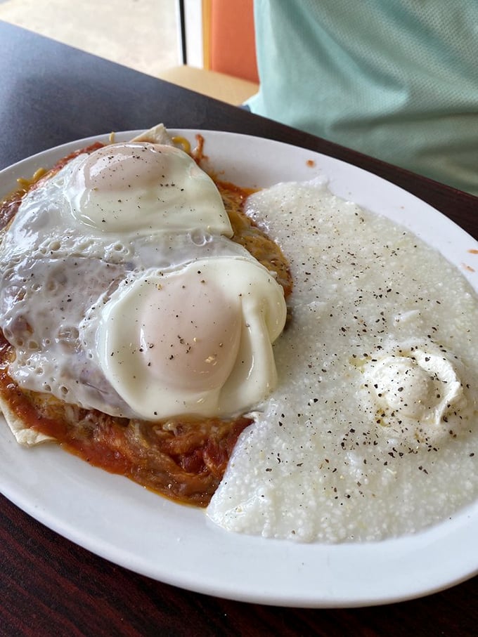 Eggs perched atop a spicy tomato sauce with a side of creamy grits – breakfast that doesn't just wake you up, it gives you a reason to live.
